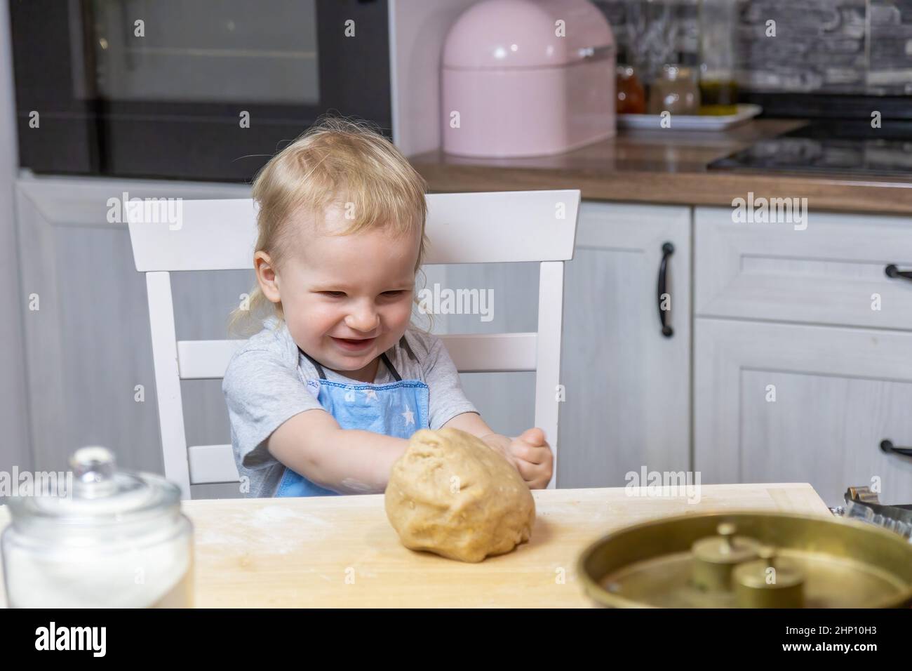 Little boy rejoices over the finished dough for sweet pastries in the ...