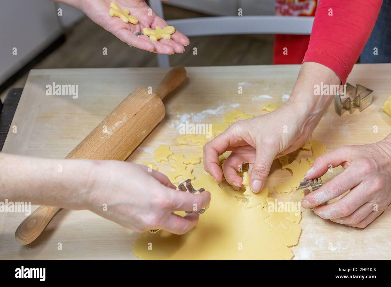Two women cut out cookies from dough in domestic kitchen, indoors ...
