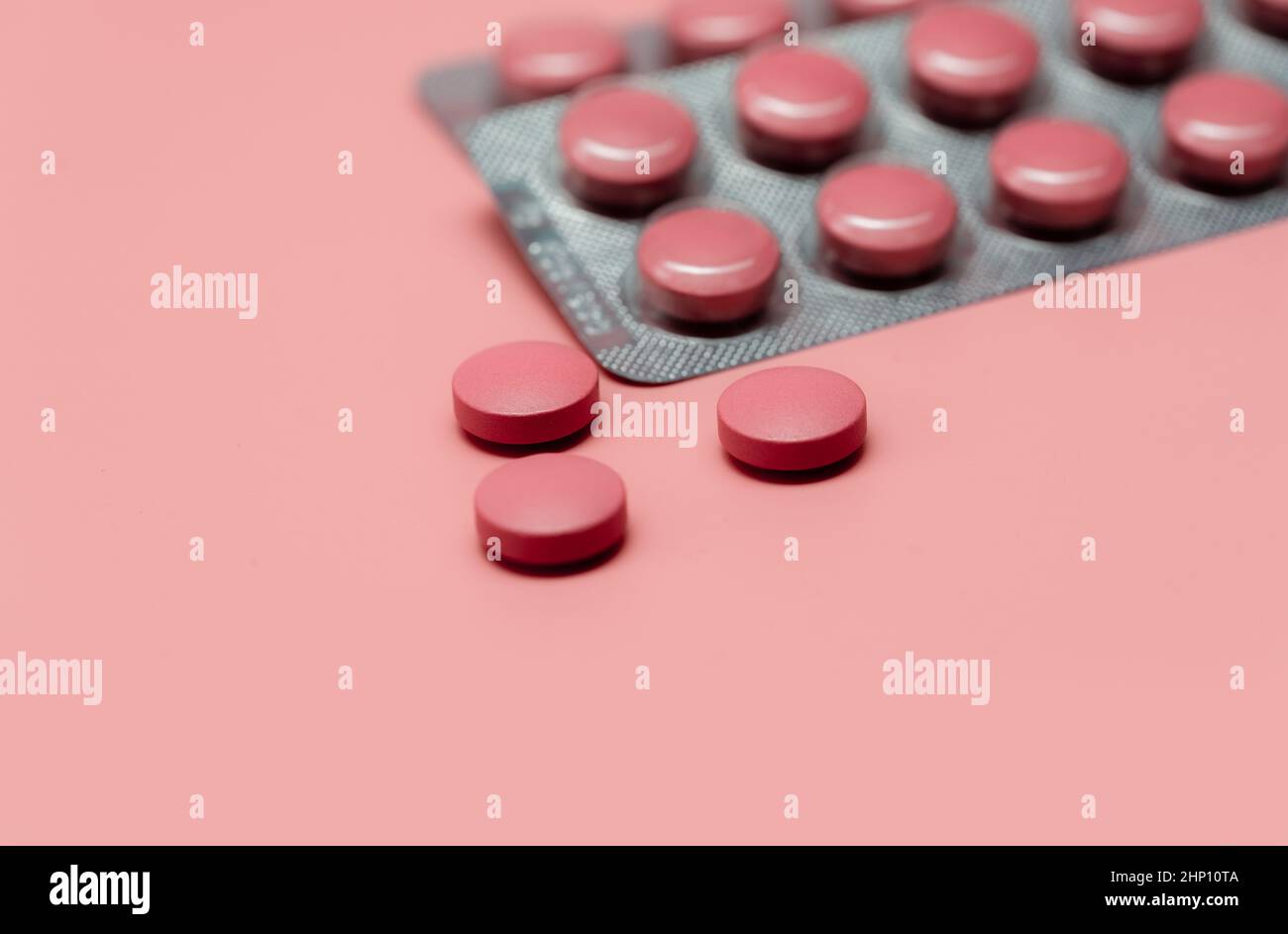 Pink tablets pill on blur blister pack of tablets pills on pink ...