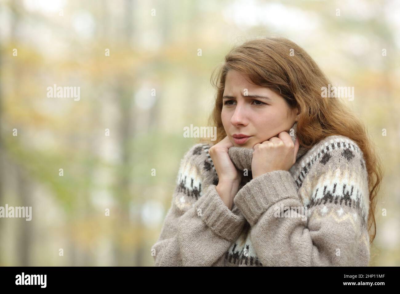 Stressed woman getting cold in winter standing in a park Stock Photo ...