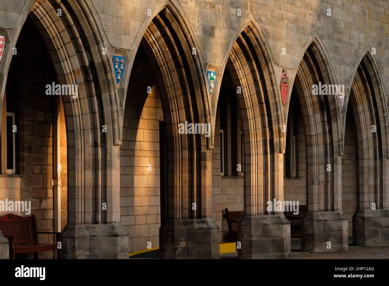A colour photograph of the stone arches and cloistered walkway which ...