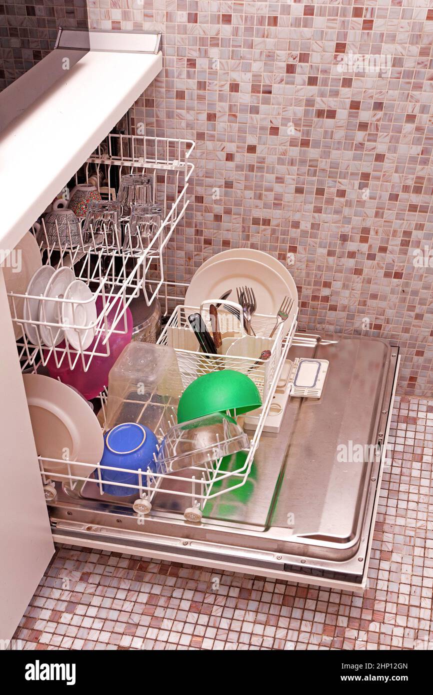 Clean dishes inside open dishwasher machine inside home interior Stock ...