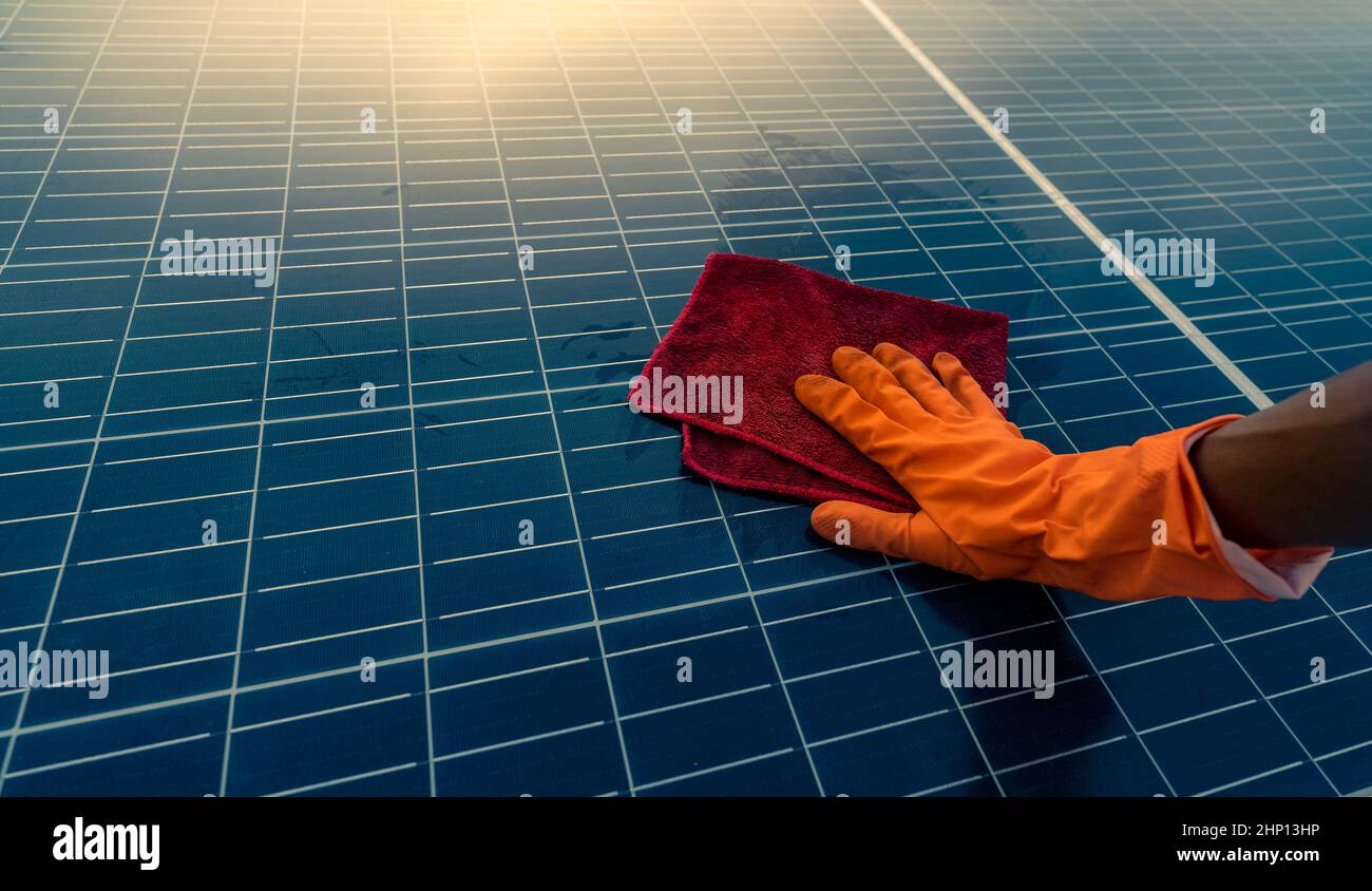 Man cleaning solar panel on roof. Solar panel or photovoltaic module ...