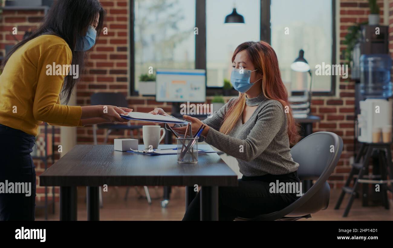 Asian employee with face mask attending job interview with candidate in ...