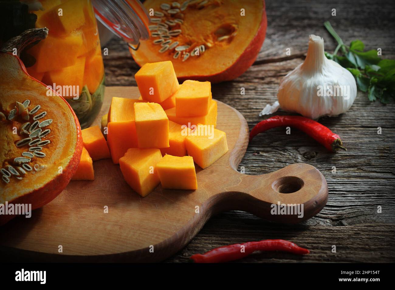 Fresh homemade Pumpkin pickle in a glass and herbs on a wooden table ...