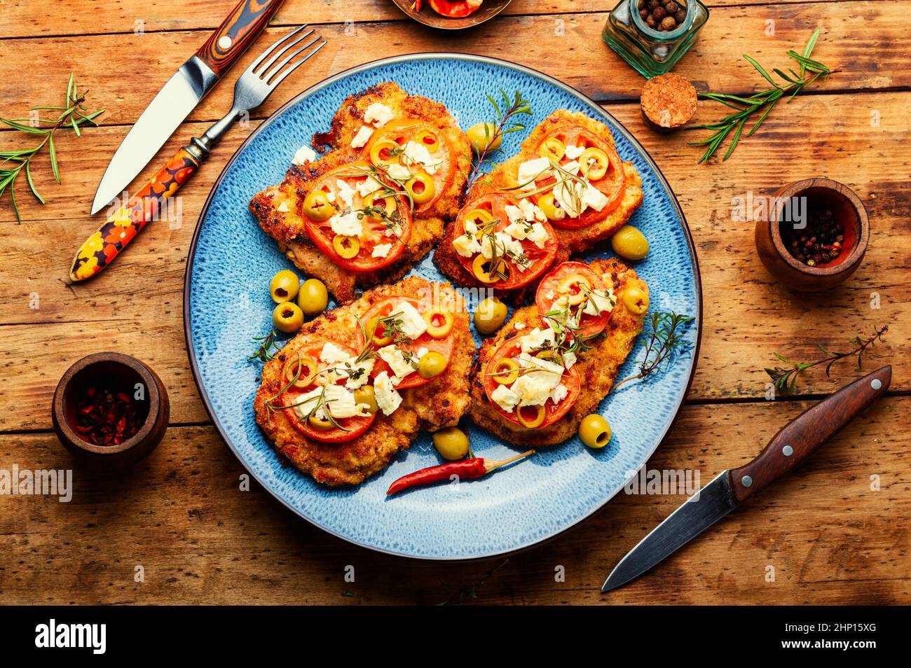 Thin layer of meat, breaded in breadcrumbs with cheese, olives and ...