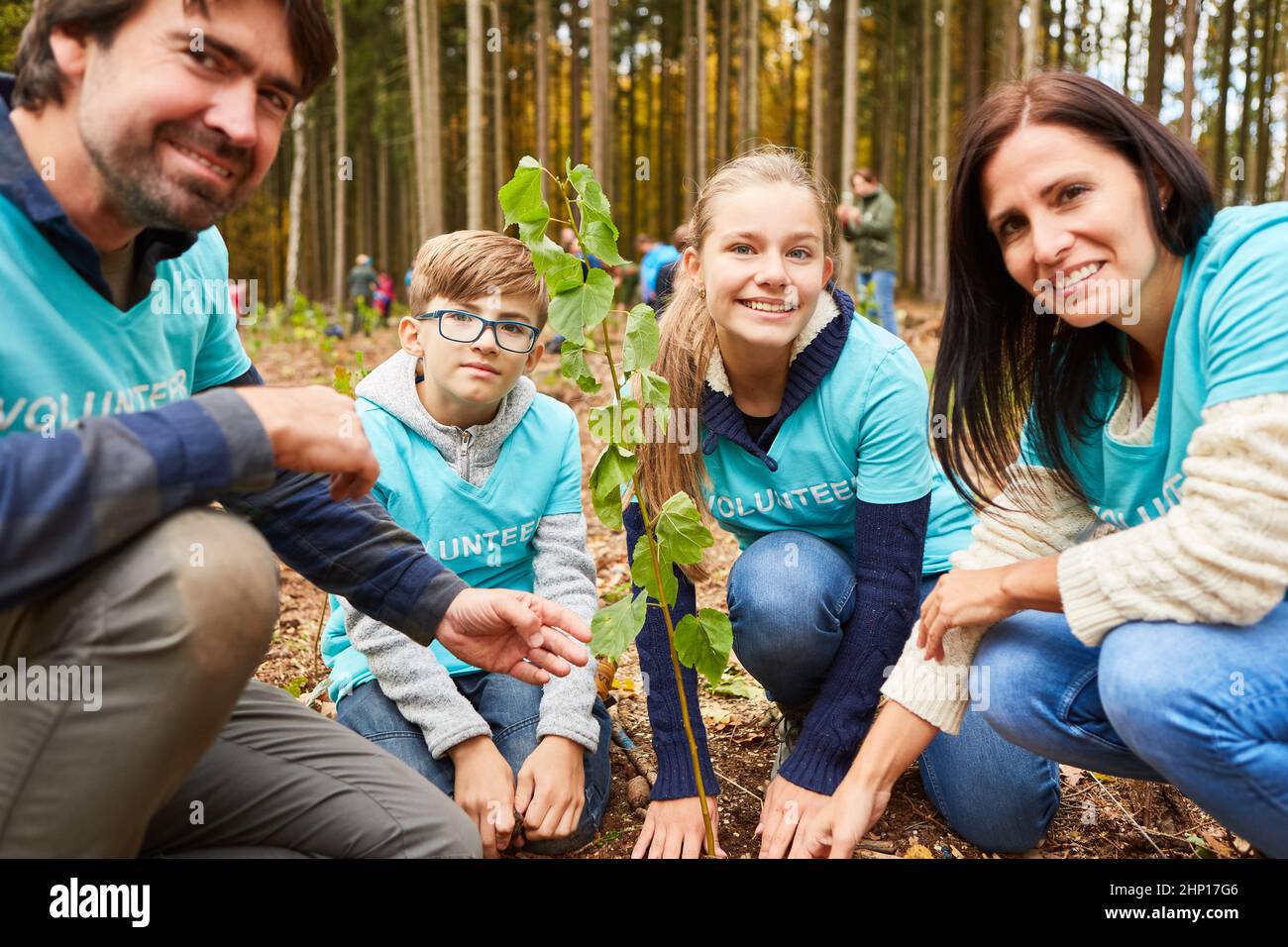 Happy family with two children plants a climate tree for sustainable ...