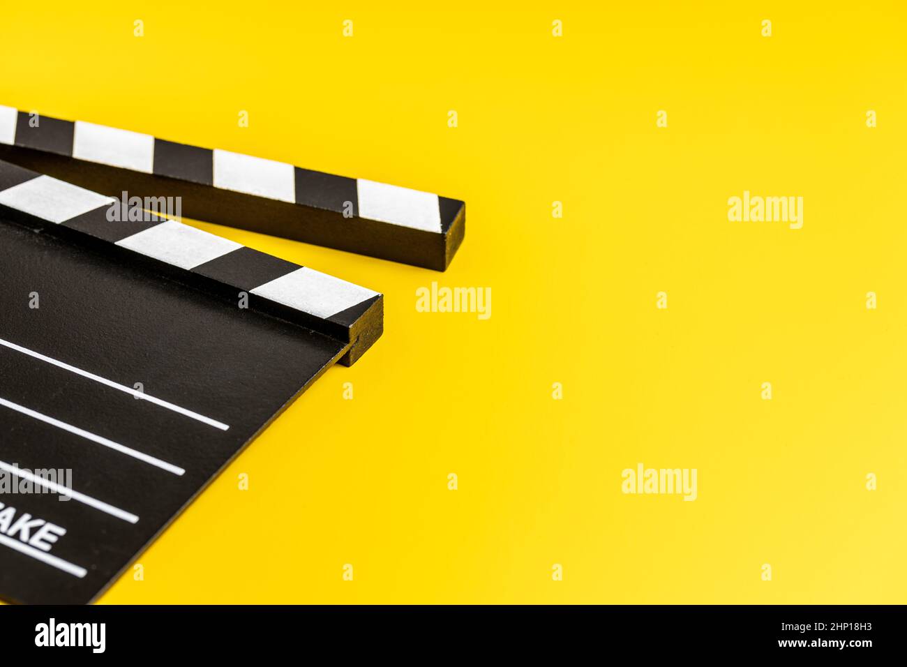 Black clapper board on yellow background Stock Photo - Alamy