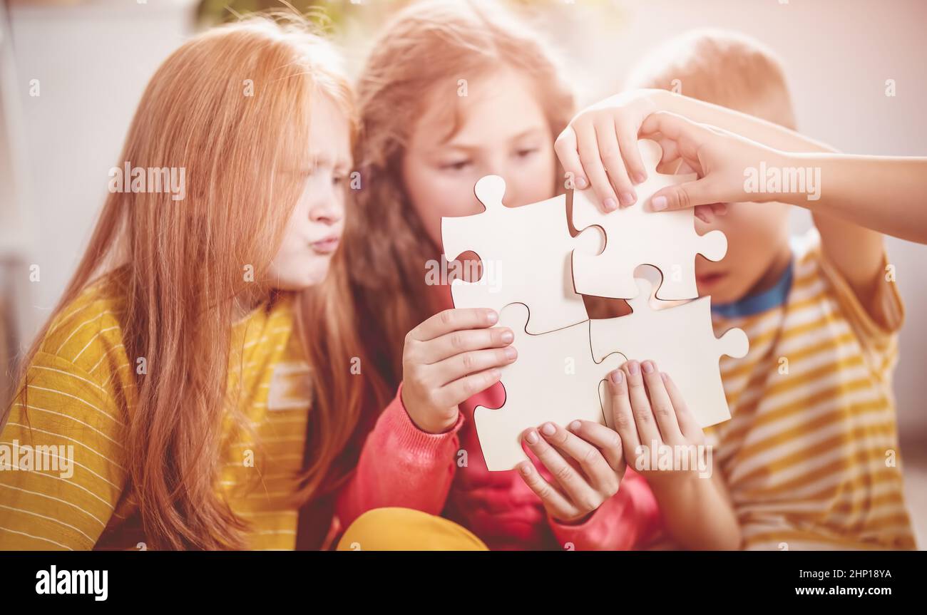 Group of children indoors playing together in jigsaw. Concept of ...