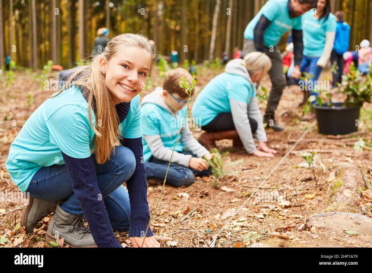 Children and family as volunteers planting trees in the forest for ...