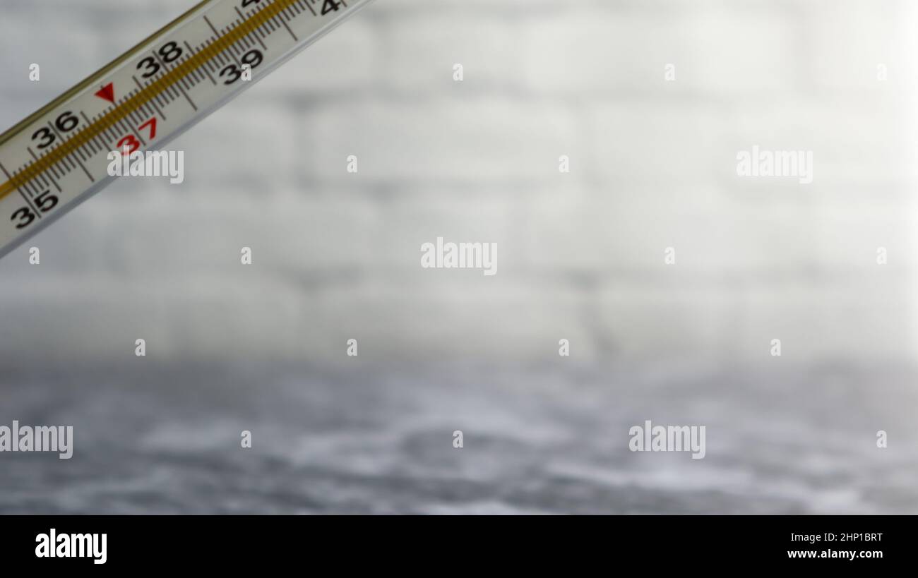 Mercury thermometer on a white surface with copy space on the right ...