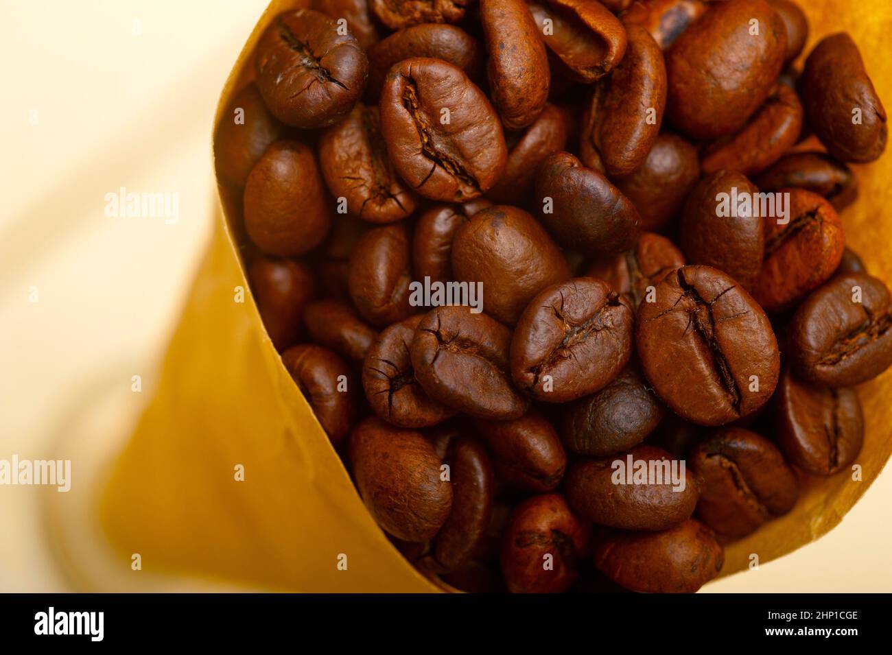 espresso coffee beans on a paper cone cornucopia over white background ...