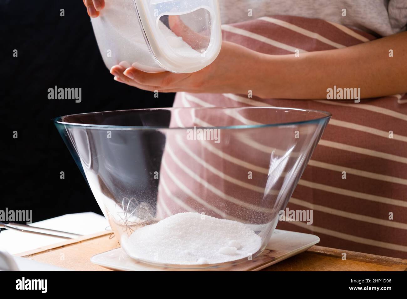 Close up woman pouring flour into a mixing bowl for preparation of ...