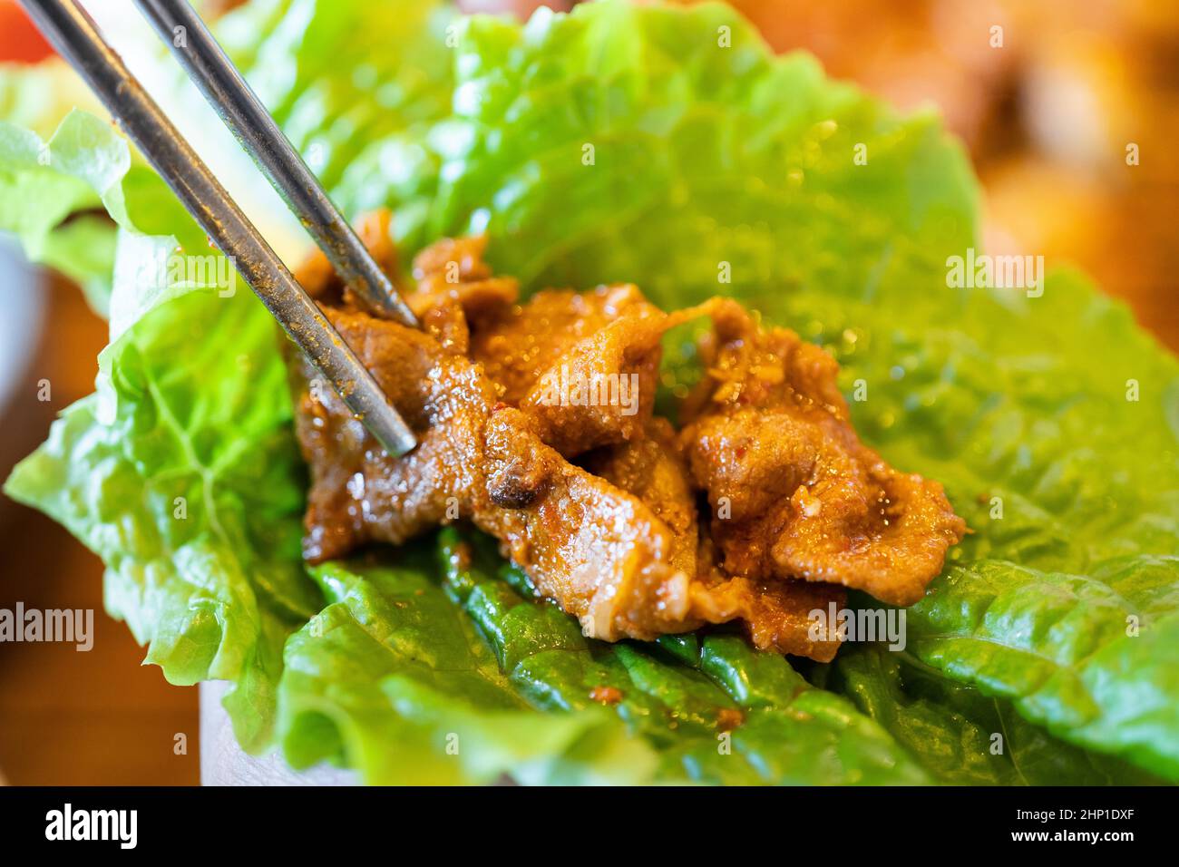 Close up of ssam Korean BBQ, pan-fried black pork with lettuce meal in ...