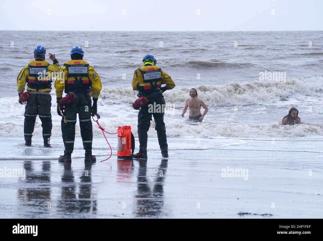 A coastguard search and rescue team ask a group of swimmers to come out ...