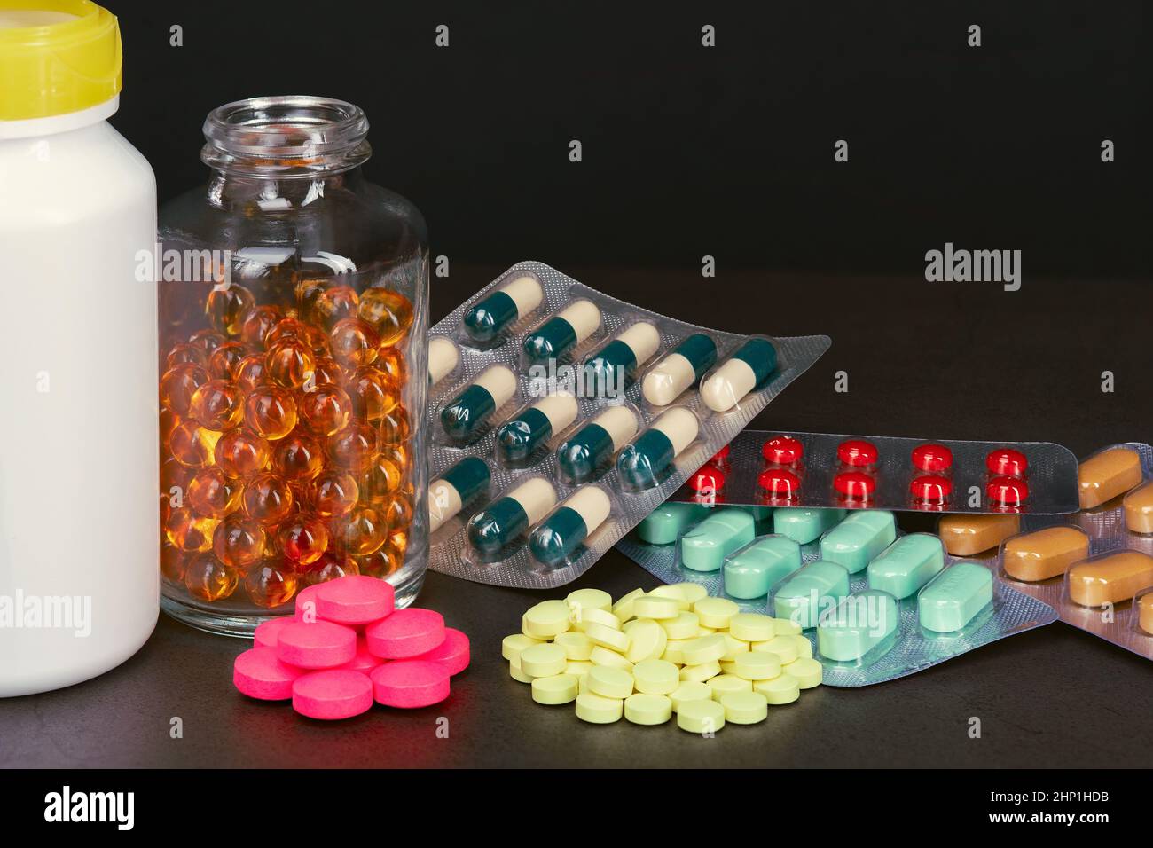 Colorful pills, blister and syringe on a black background Stock Photo ...