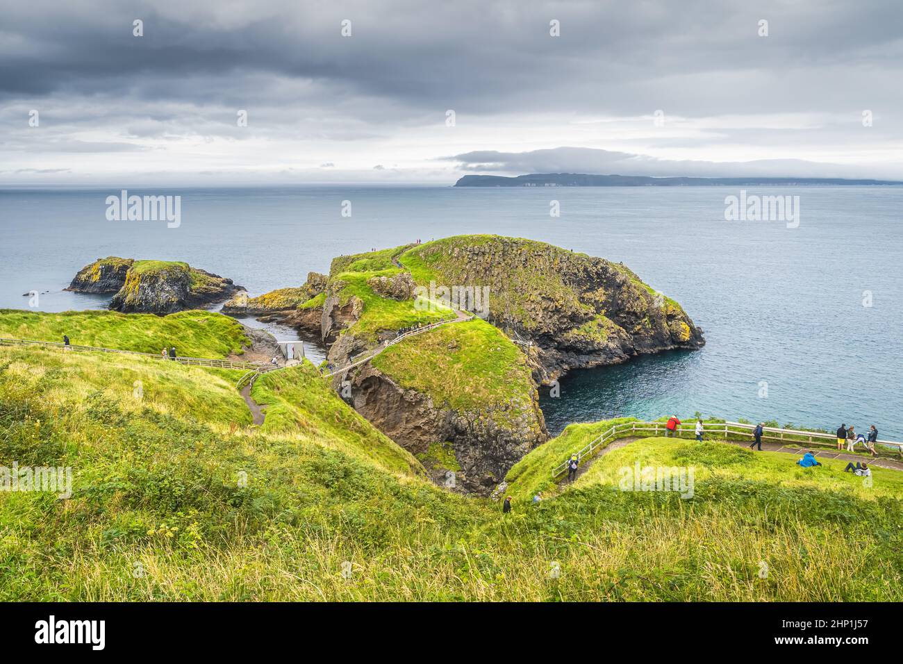 Tourists sightseeing the Carrick a Rede rope bridge and scenic island ...