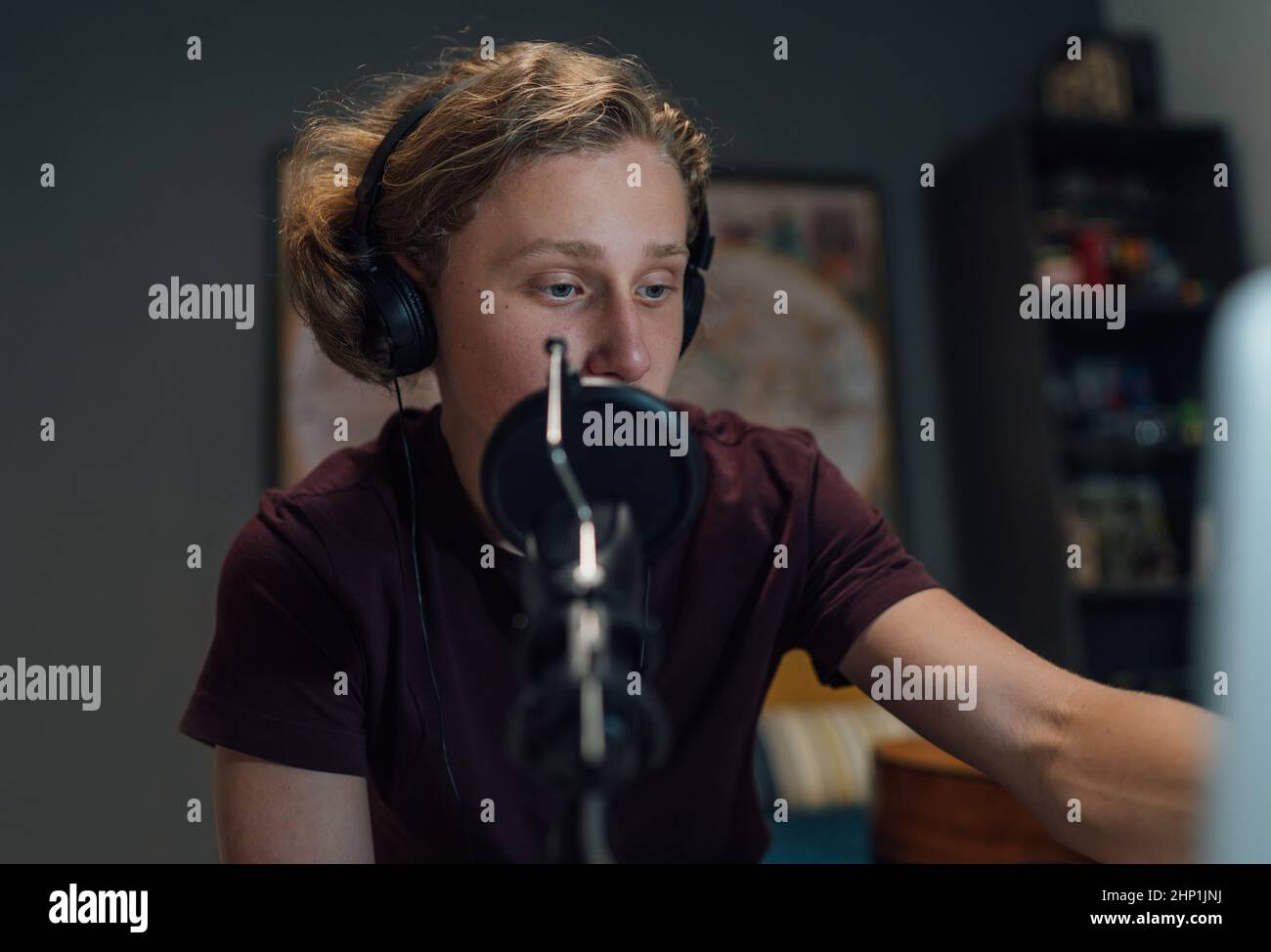 Portrait photo of a young teenager boy in headphones recording voice ...