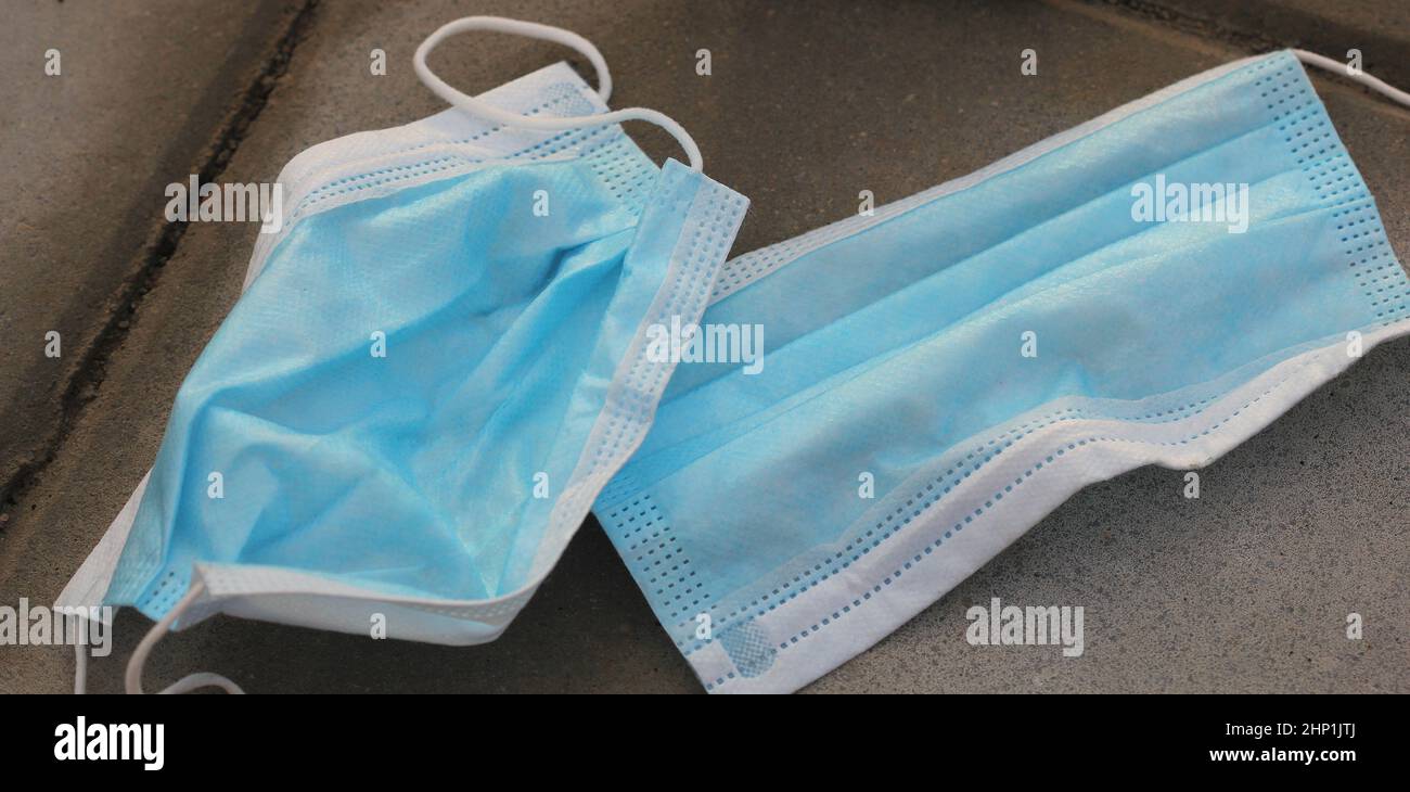 Used medical face mask thrown out on the street waste littered in the ...