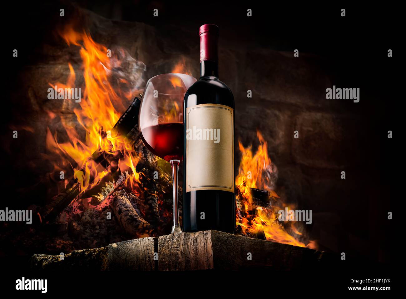 Glass and bottle of red wine on fire background Stock Photo - Alamy