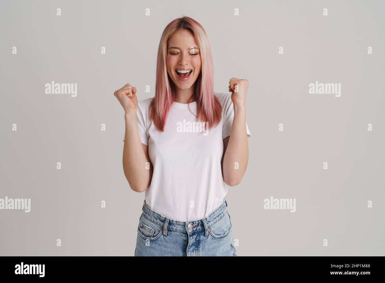 Young excited woman screaming and making winner gesture isolated over ...