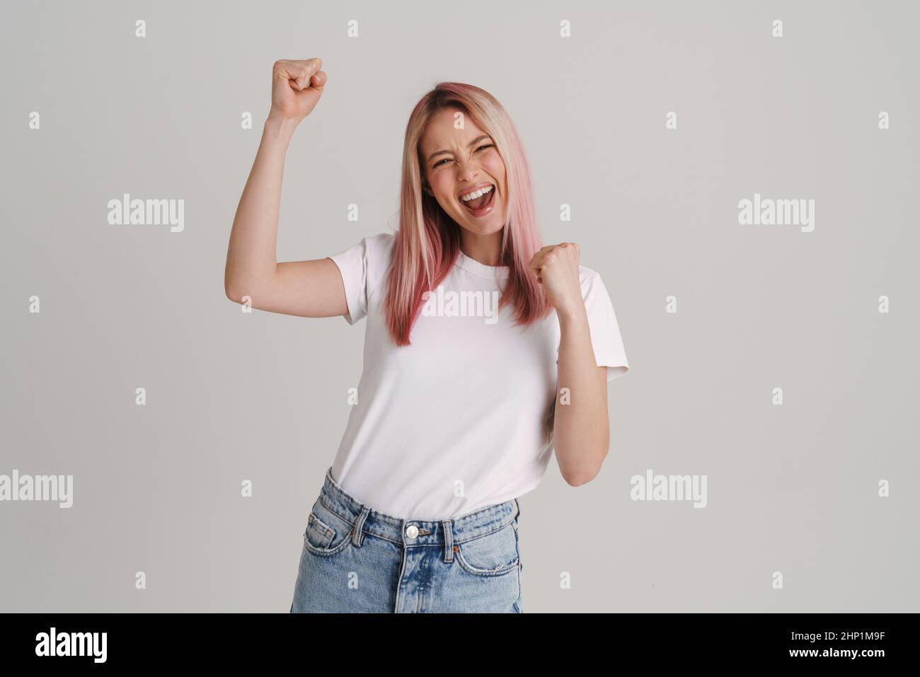 Young excited woman screaming and making winner gesture isolated over ...