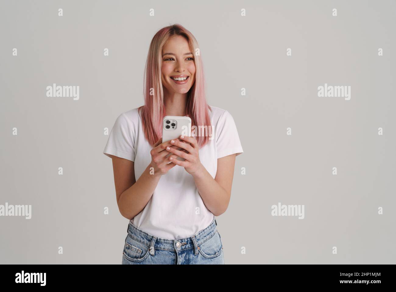 Young european woman smiling while using mobile phone isolated over ...
