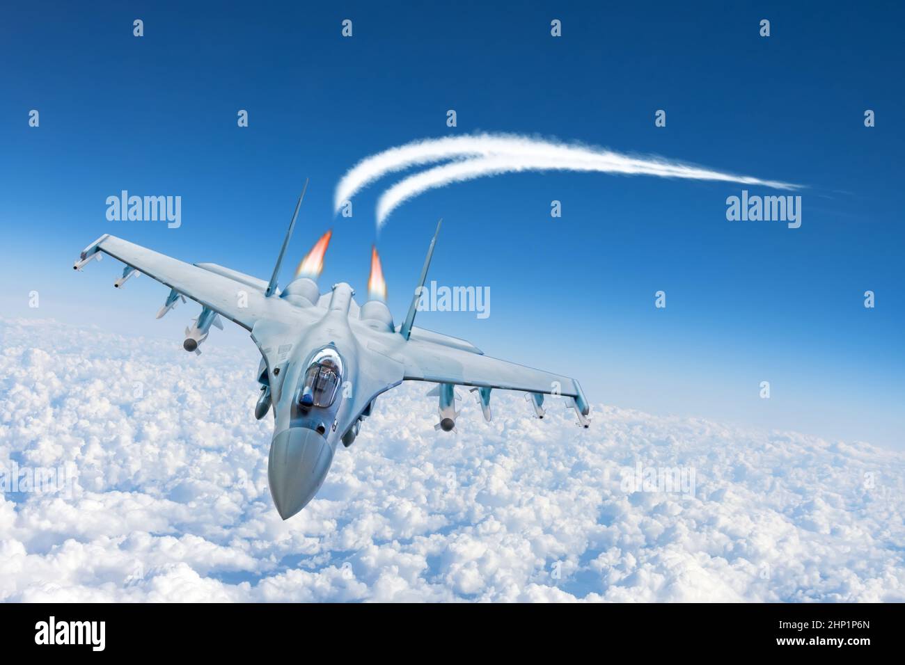 Military jet fighter aircraft flying on a high altitude over the clouds ...