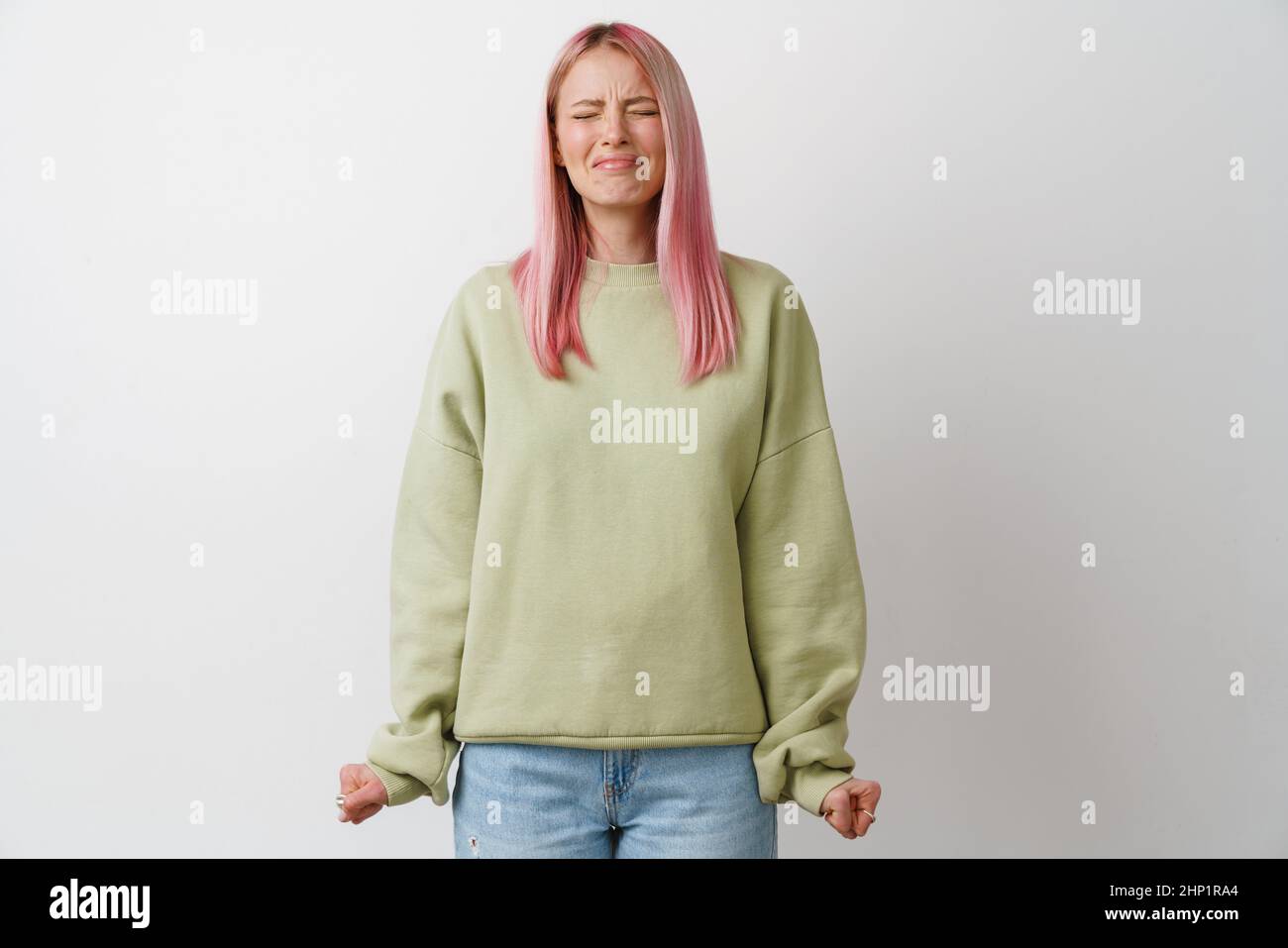 Young white woman with pink hair crying and clenching her fists ...