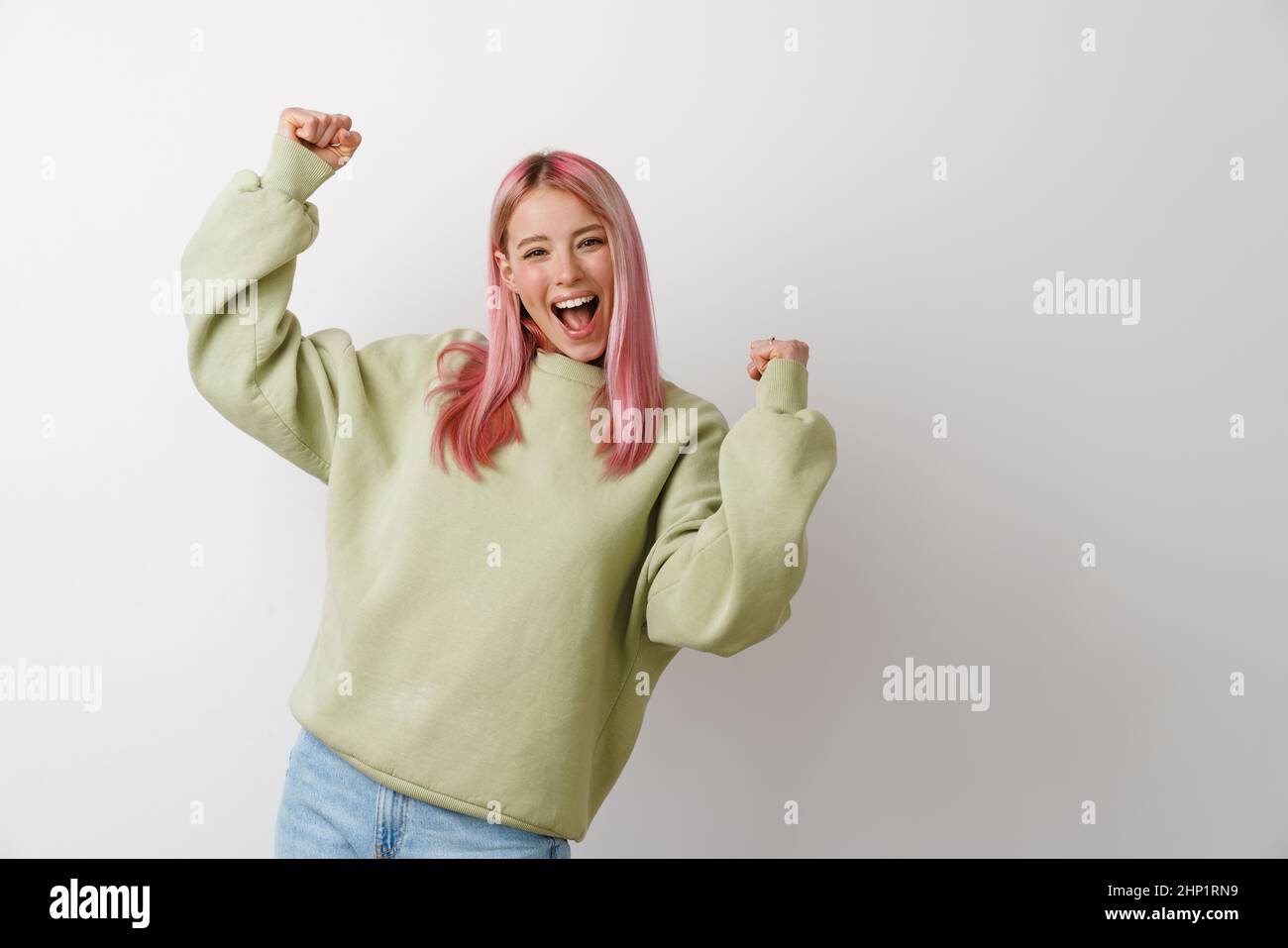 Young excited woman screaming and making winner gesture isolated over ...