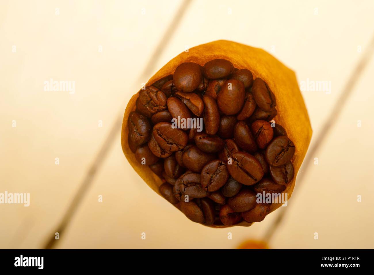 espresso coffee beans on a paper cone cornucopia over white background ...
