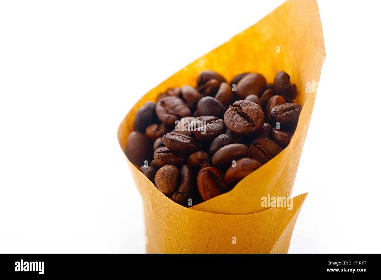espresso coffee beans on a paper cone cornucopia over white background ...