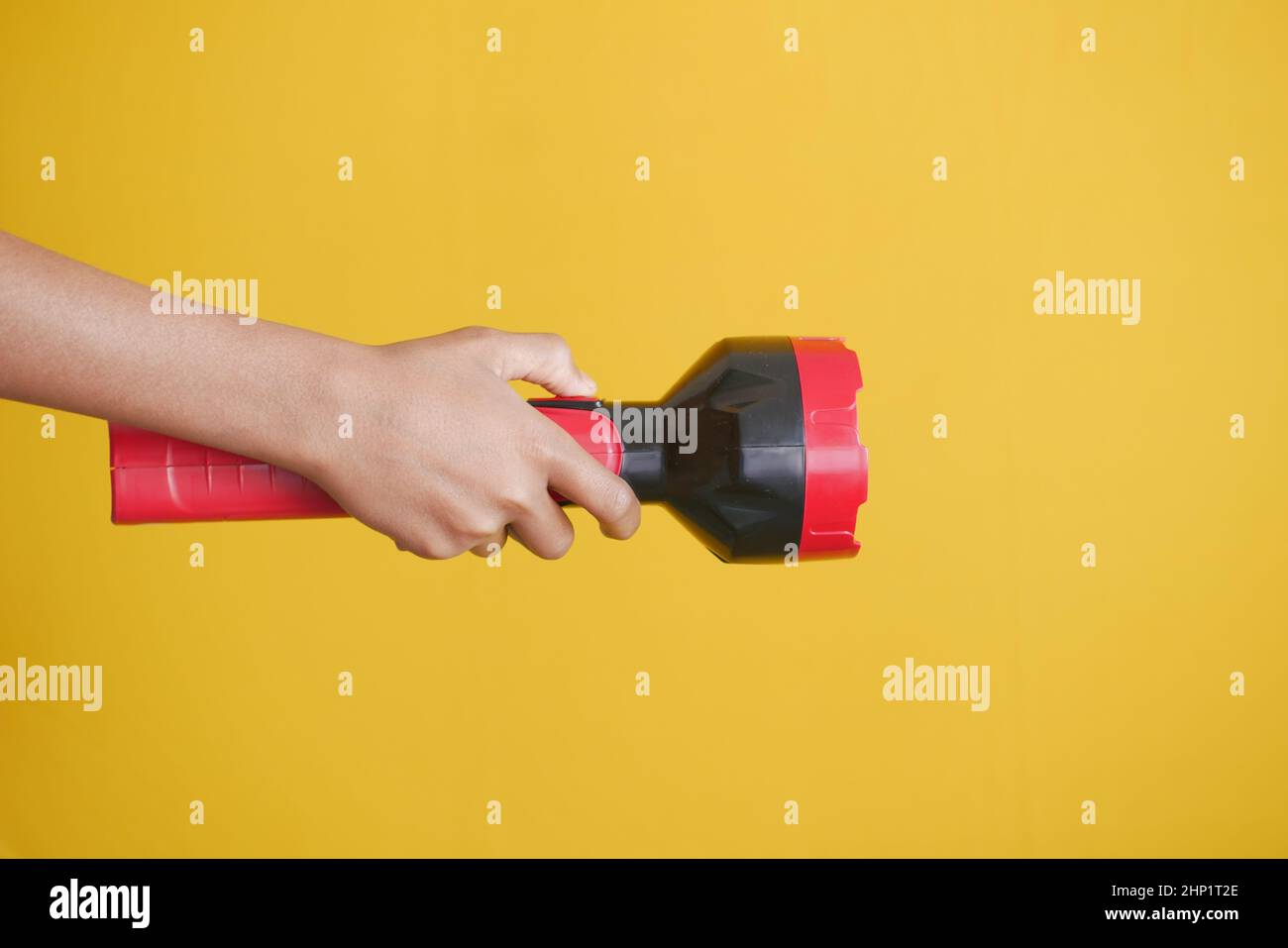 hand holding a tourch light against yellow background Stock Photo - Alamy