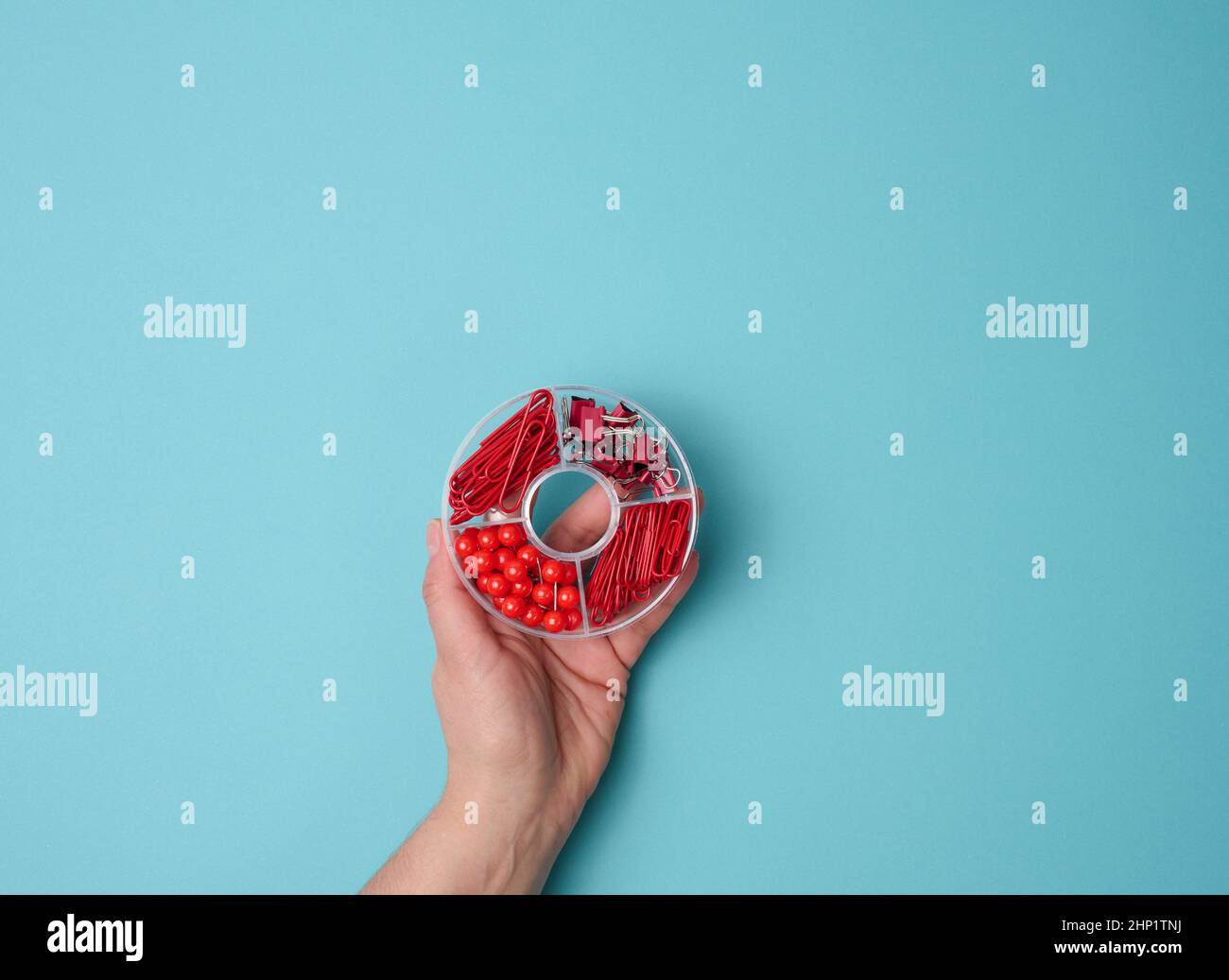 hand holds set of stationery objects: paper clip, buttons and clip on a ...