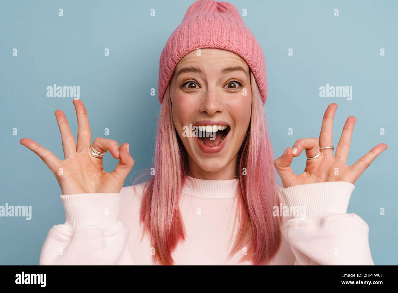 Young white woman with pink hair laughing and showing okay sign ...