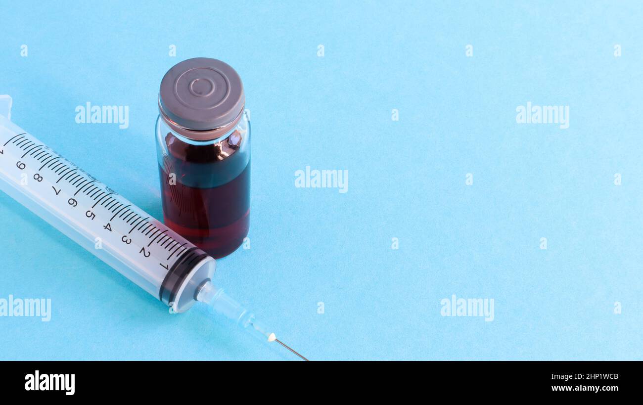 One medical glass bottle with red potion on a blue background and a ...