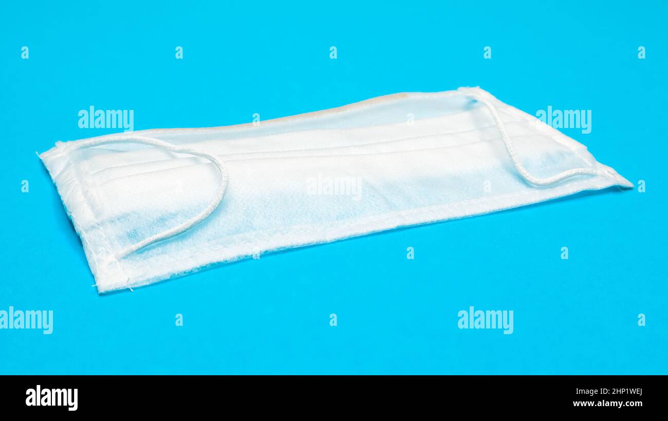 One 3-ply disposable surgical face mask with rubber grips covering ...