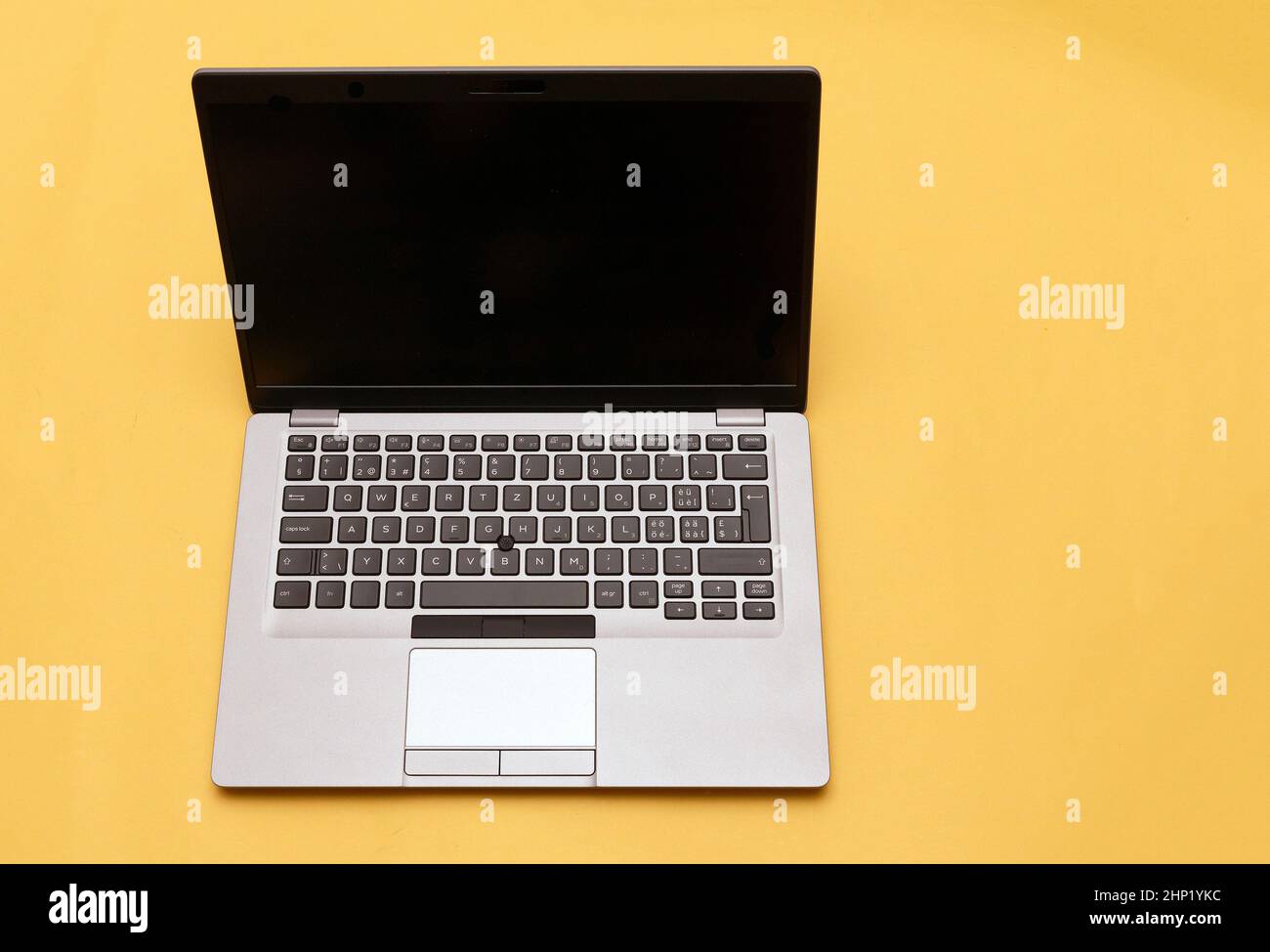 Open modern PC laptop with empty black screen on yellow background ...