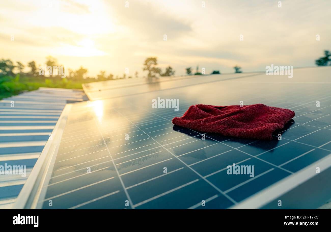Red microfiber cloth cleaning solar panels or photovoltaic module ...