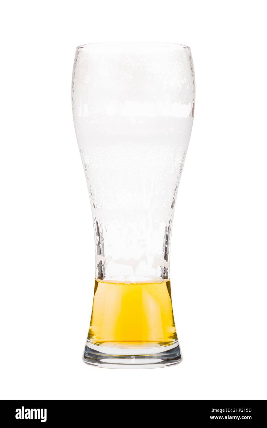 Tall beer glass almost full with lager beer, in the process of drinking ...