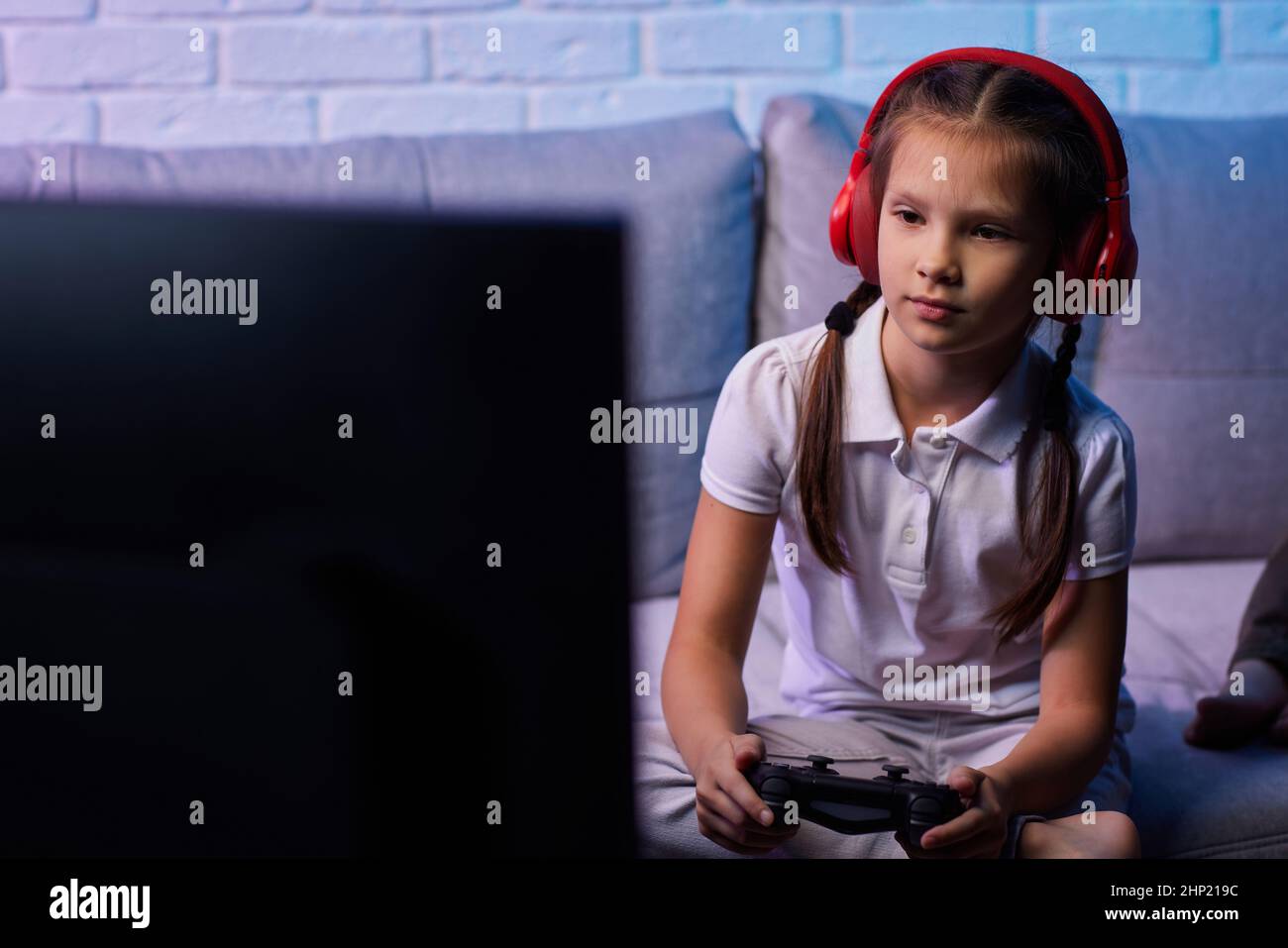 little child girl playing video game with game console at home Stock ...