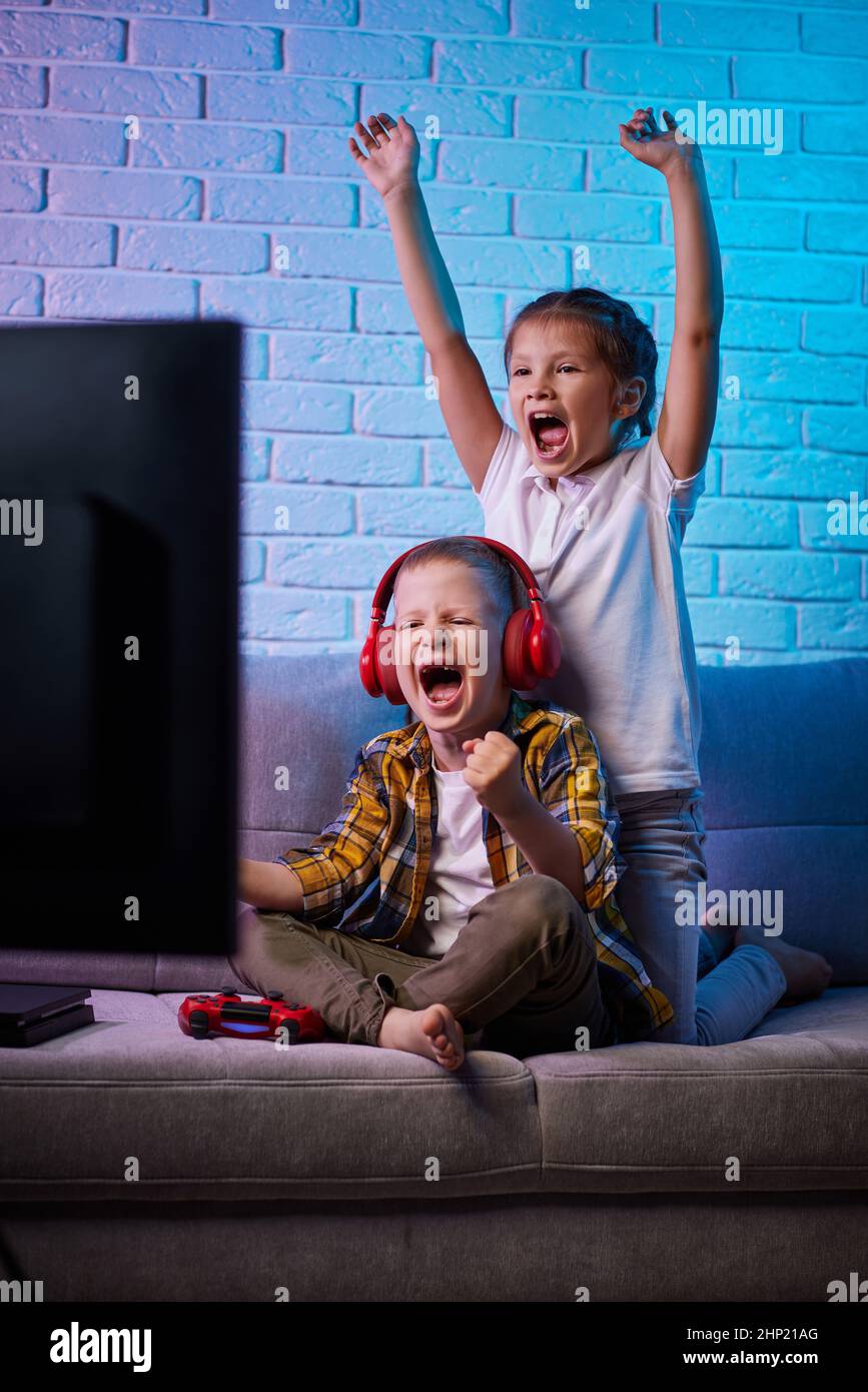 happy children playing video game with game console and celebrating ...