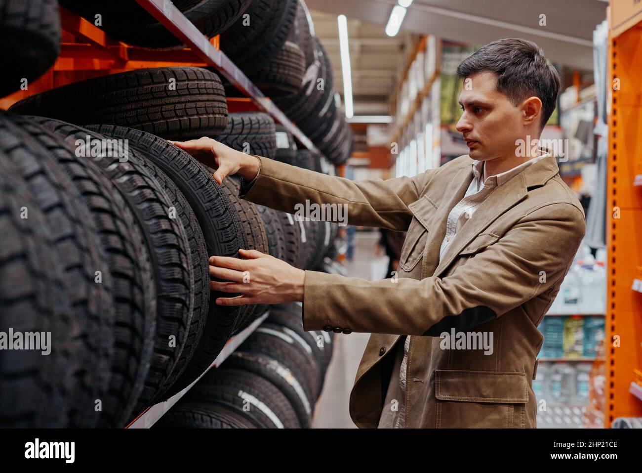 man customer choosing new tires in the supermarket. auto shop with car ...
