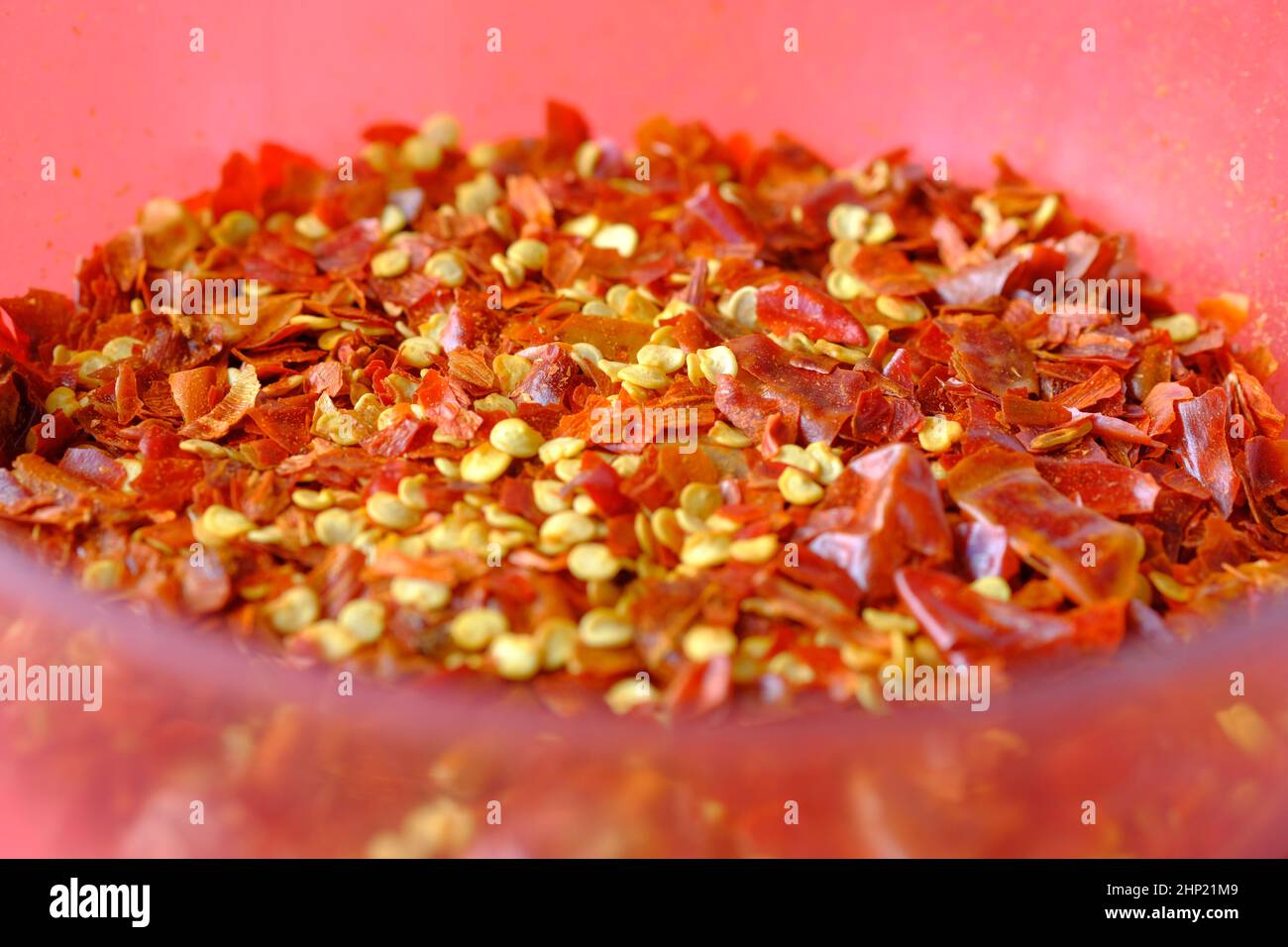 close up of red chili flakes in a bowl on red Stock Photo - Alamy