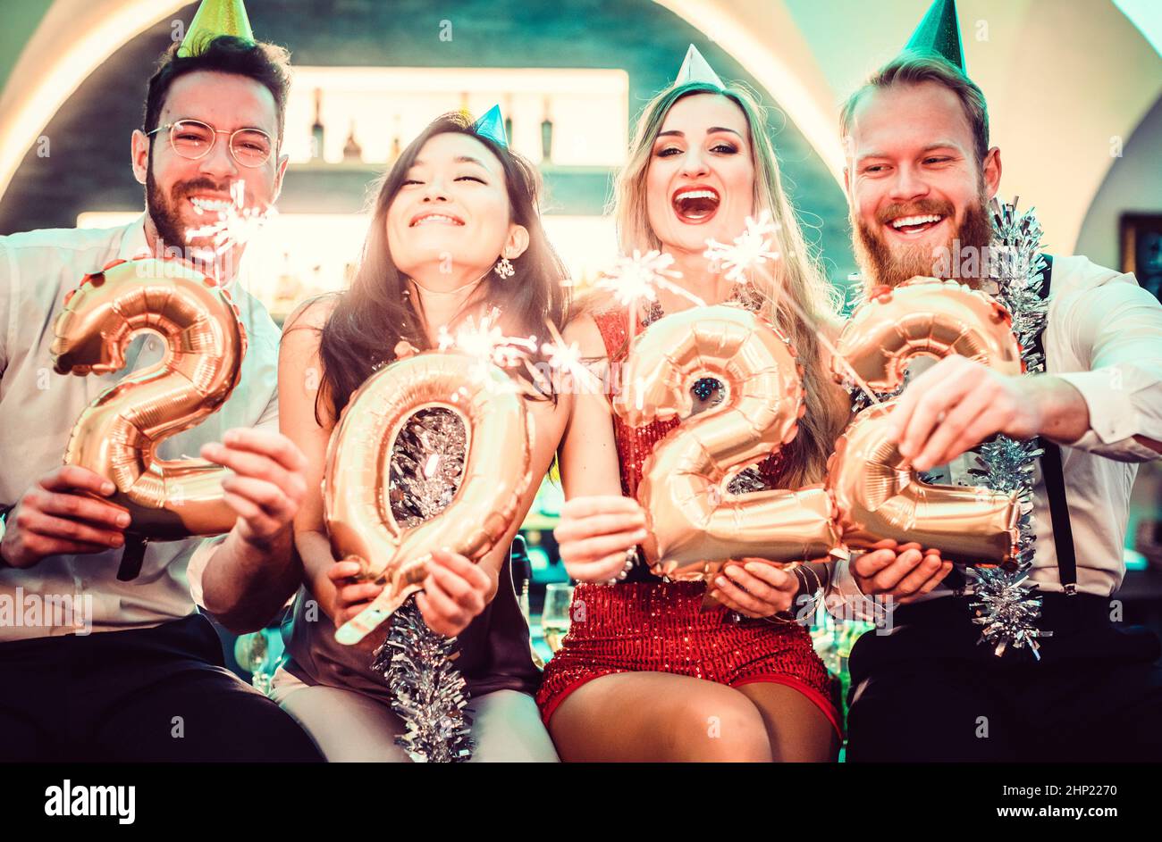 Group of party people celebrating the arrival of 2022, men and women ...