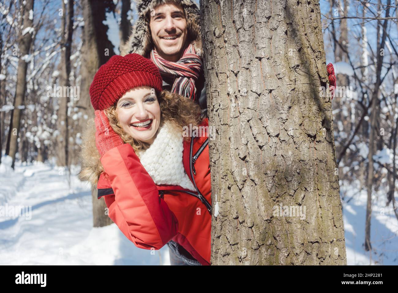 Young man hiding behind tree hi-res stock photography and images - Alamy