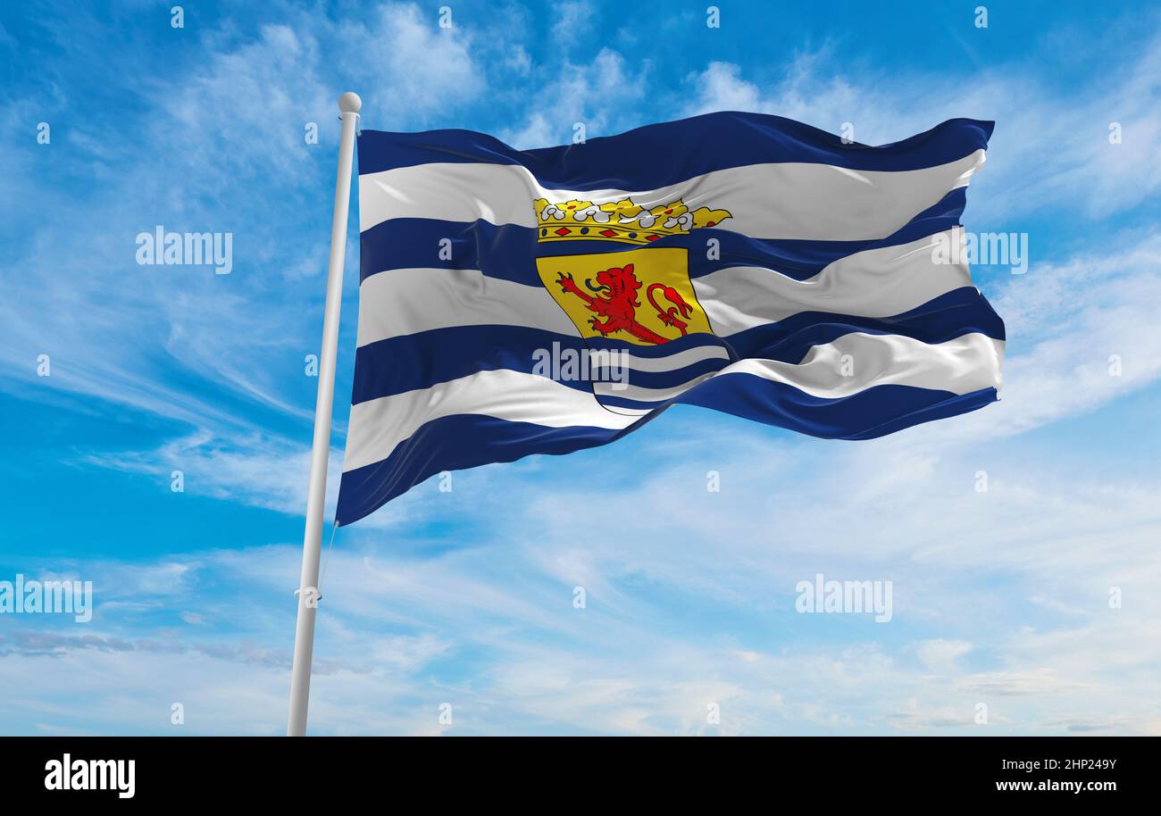 flag of Zeeland , Netherlands at cloudy sky background on sunset ...