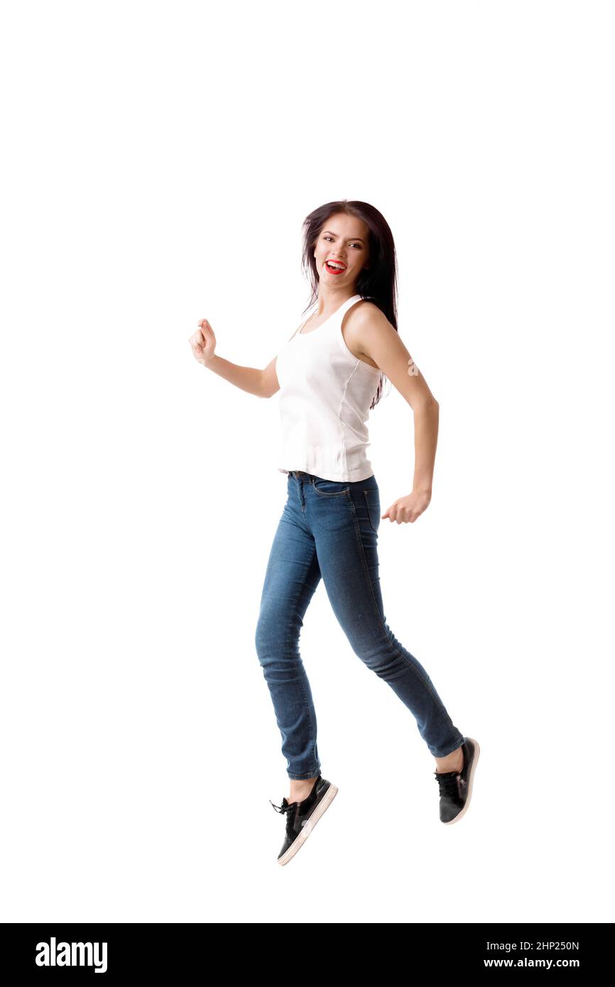 cheerful young woman is jumping and laughing on a white background ...