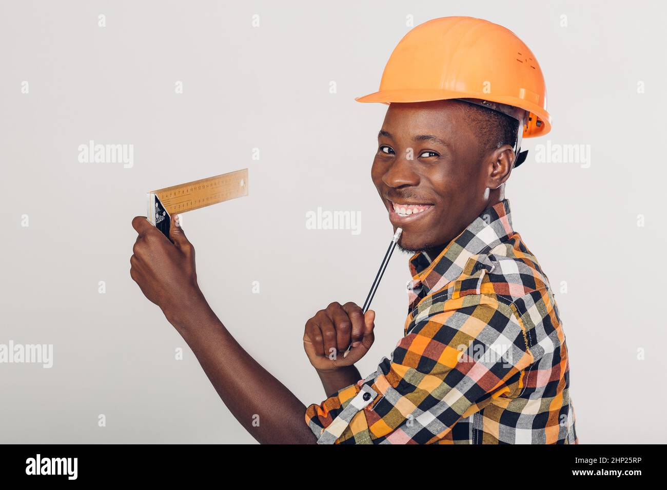smiling African American worker builder uses building ruler Stock Photo ...