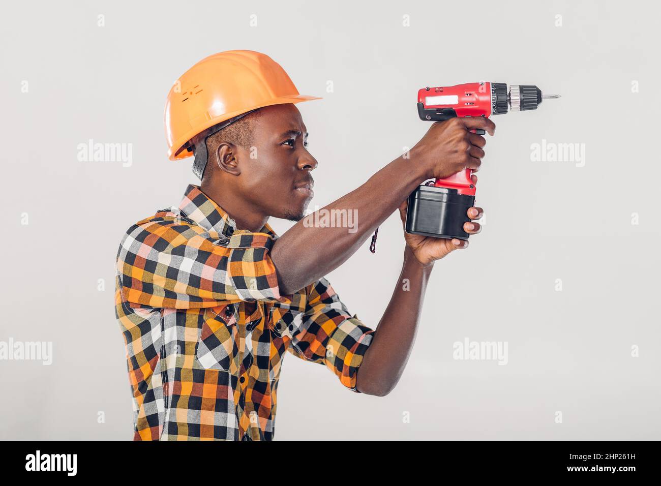 African American construction worker in helmet uses electric ...